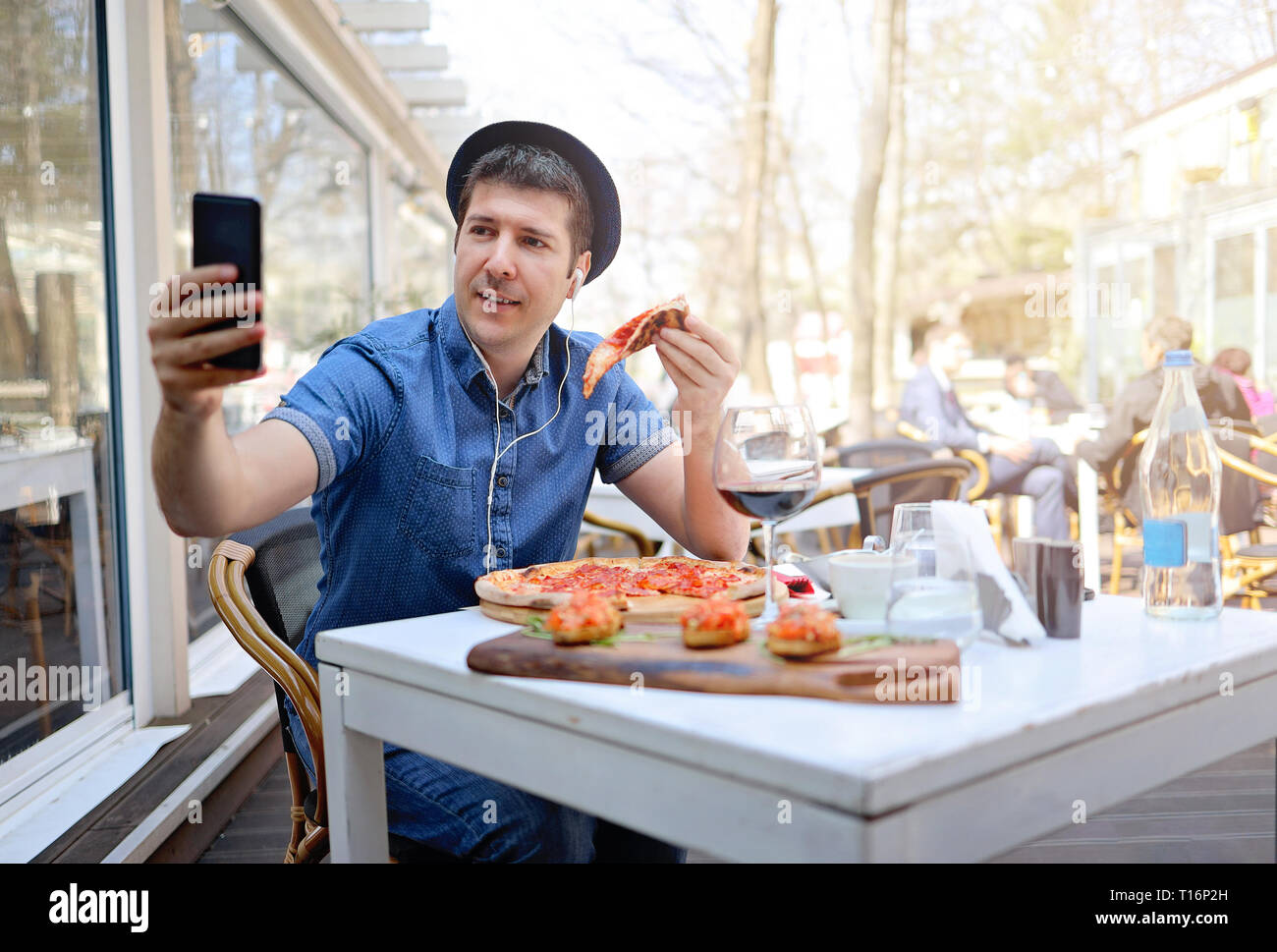 Alone tourist man taking selfie and eating a slice of pizza on italian ...