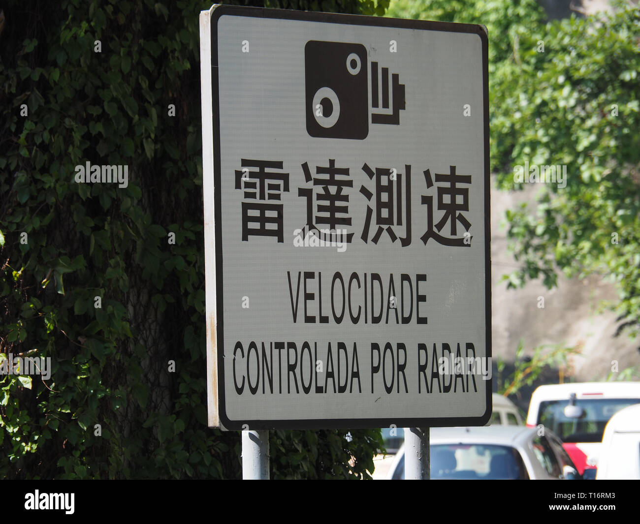 A traffic sign warns in Chinese and Portuguese for speed checks in ...