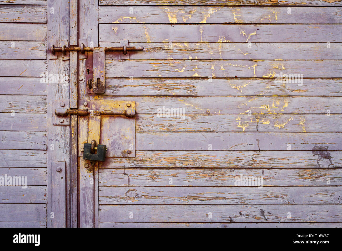 Old lilac color wooden plank door with padlock. Architecture detail ...
