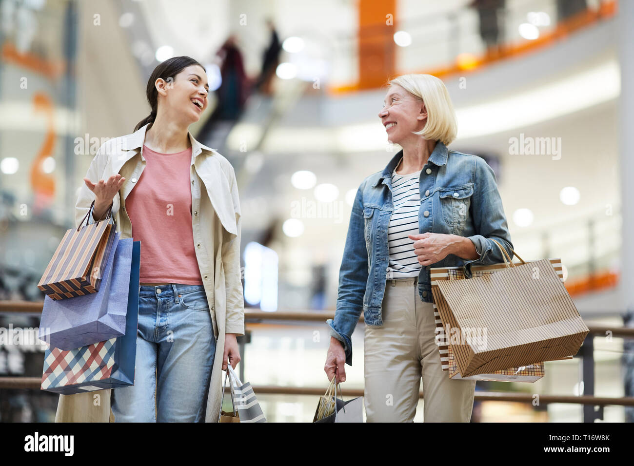 Positive ladies enjoying weekend shopping Stock Photo - Alamy