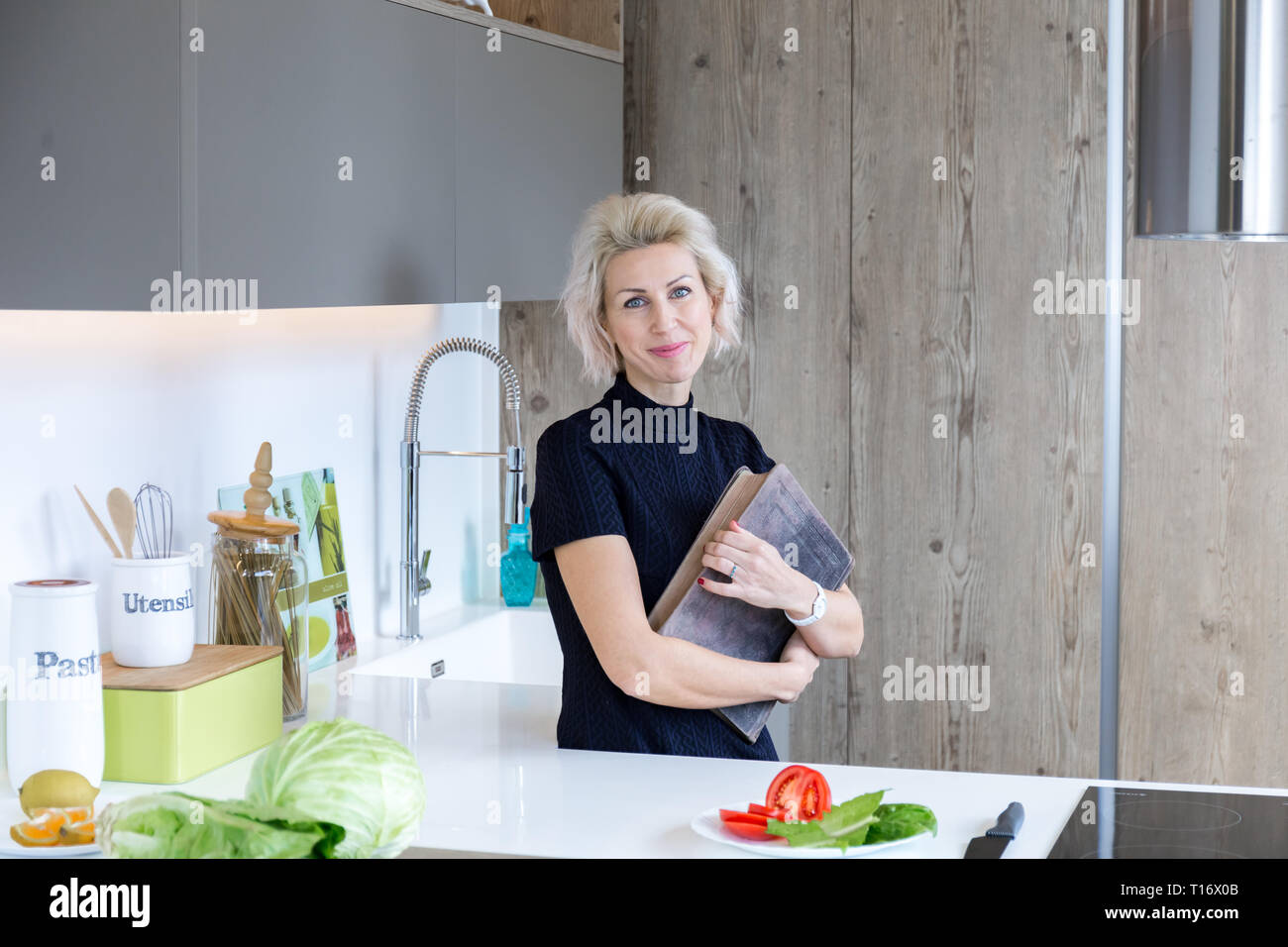 young blonde woman cooking in modern kitchen Stock Photo - Alamy