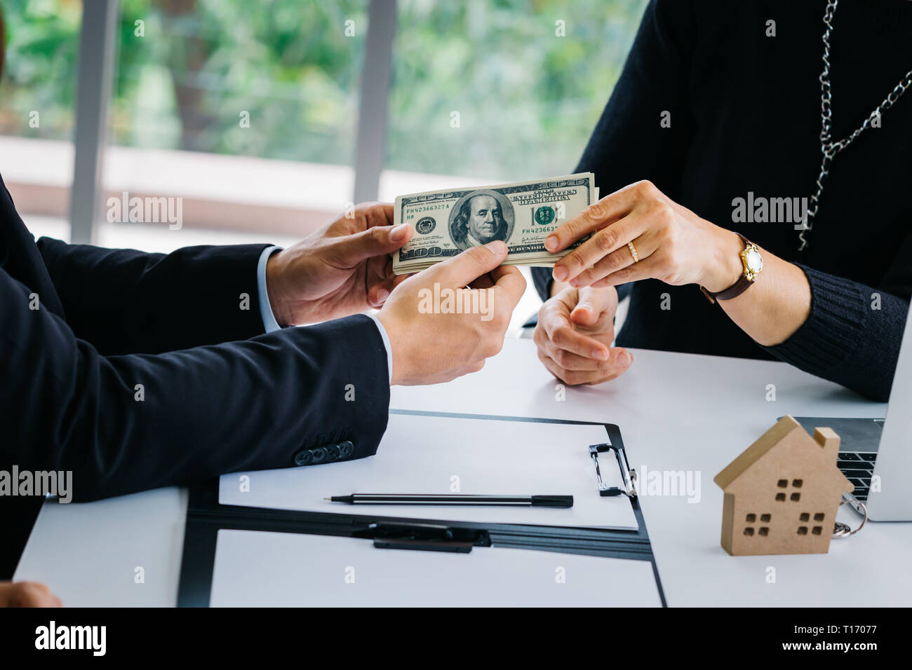 Side view of crop business people handing over dollars with decorative ...