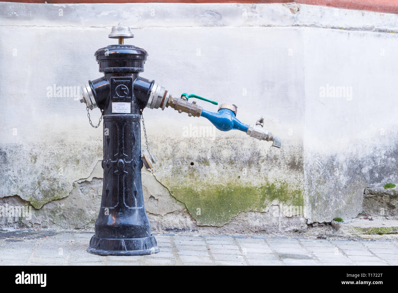 Old style black fire hydrant with attached water meter in Sopron ...