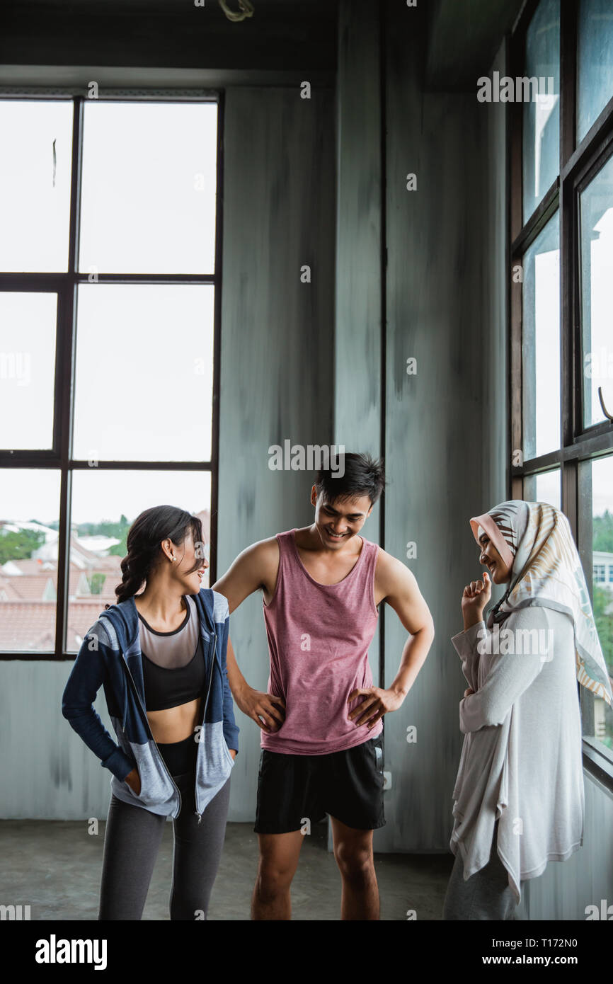 smiling friends after exercising at the gym talking Stock Photo - Alamy