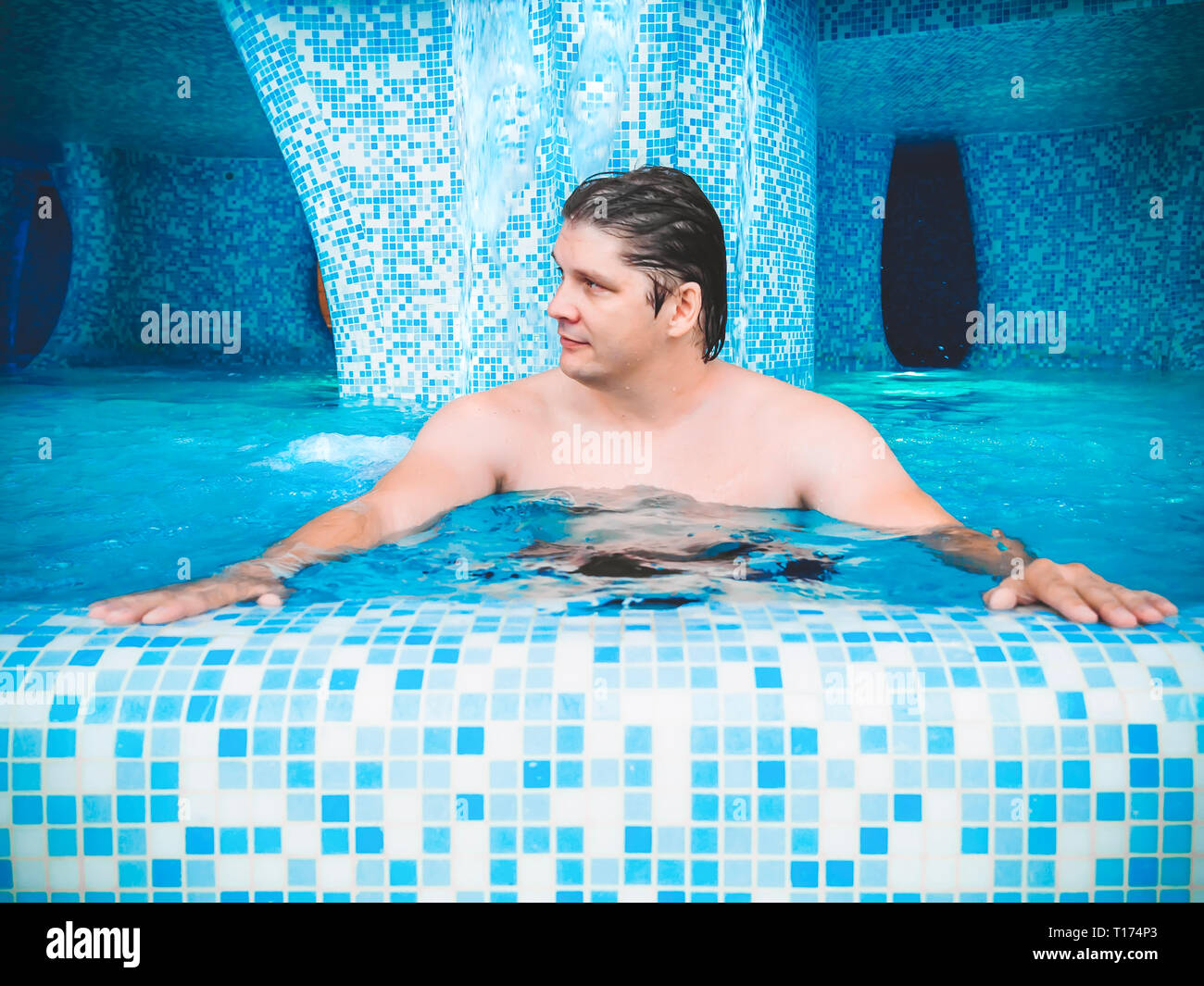 Resting man lies and relaxes in the pool.Guy is relaxing in the jacuzzi ...