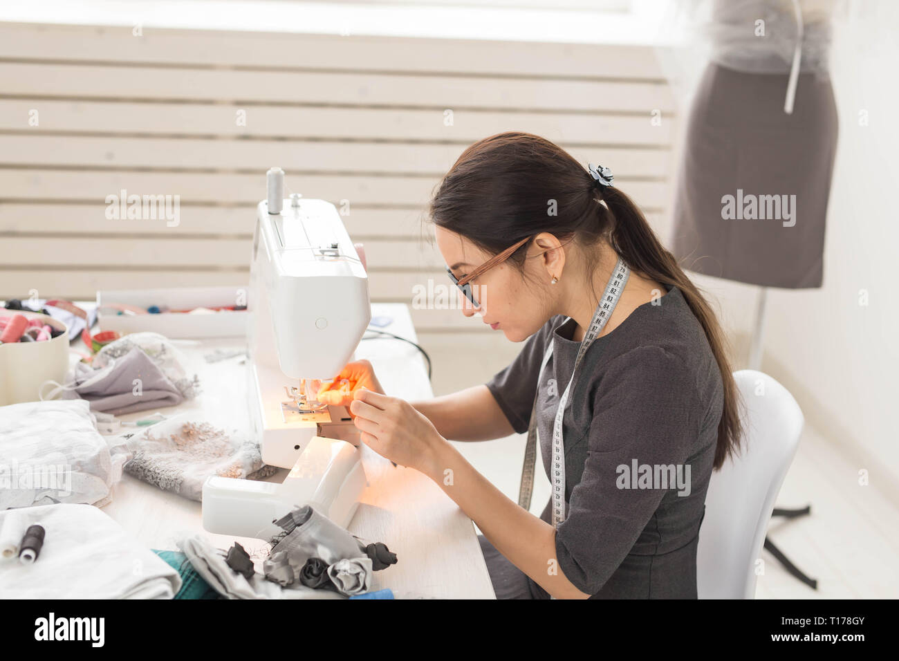 people, fashion and showroom concept - young fashion designer in her ...