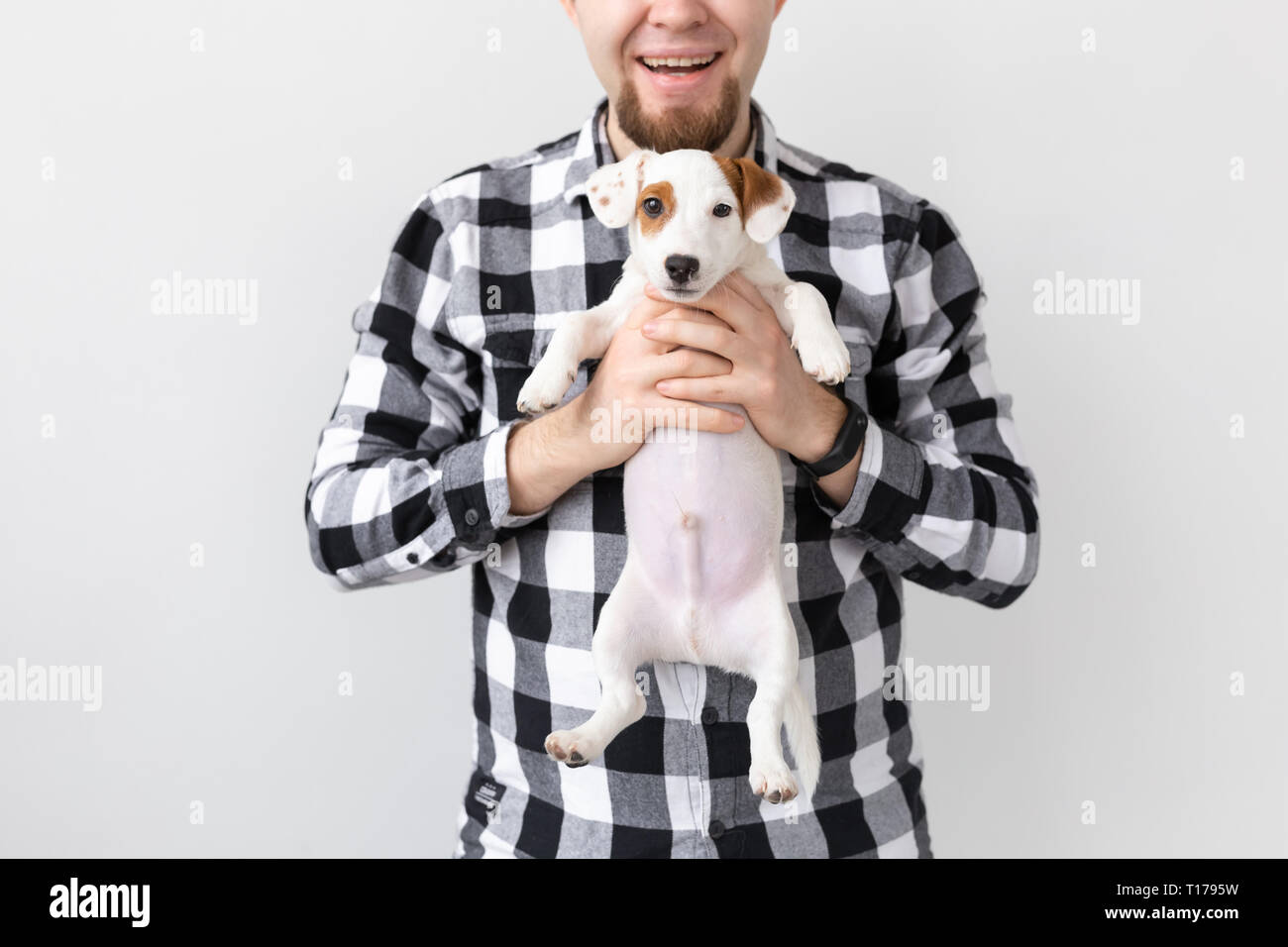 people, pets and dogs concept - close up of man hugging funny puppy on ...