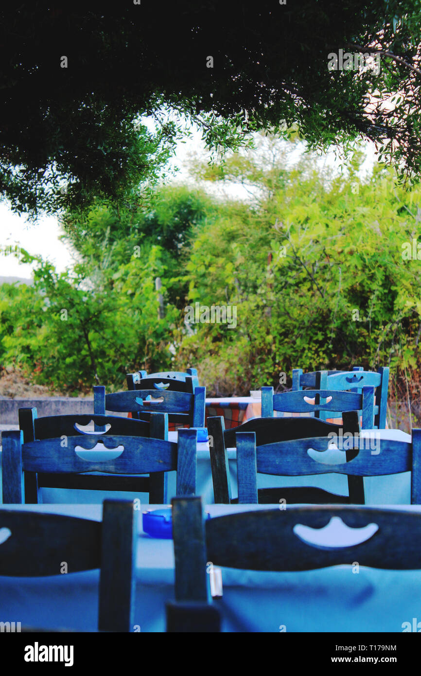 Traditional island restaurant with blue colors and green nature ...