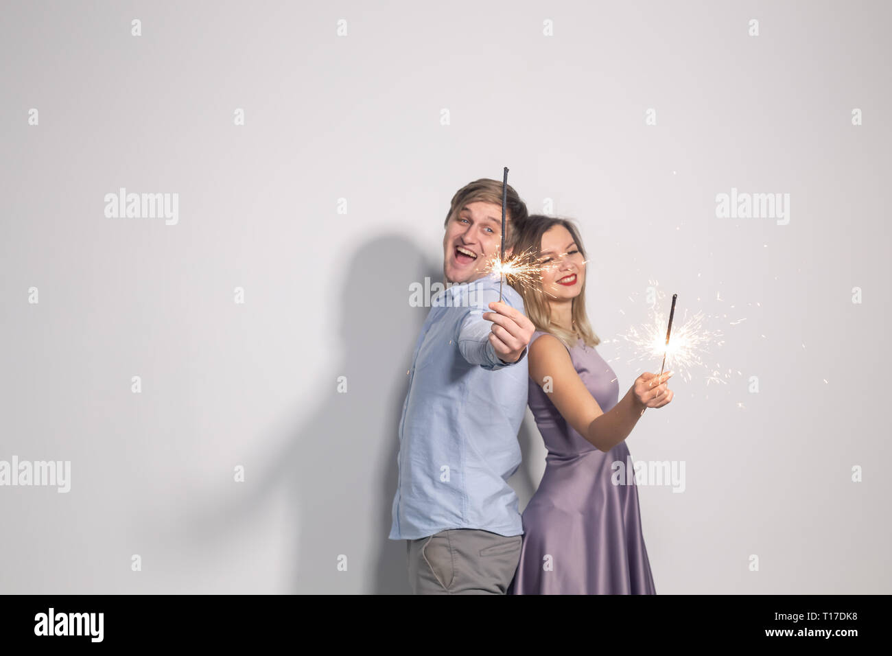 People, party and celebrations concept - young couple with sparklers ...