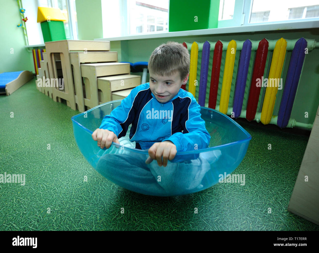 . Improving motor control: Down syndrome boy doing exercises at the ...