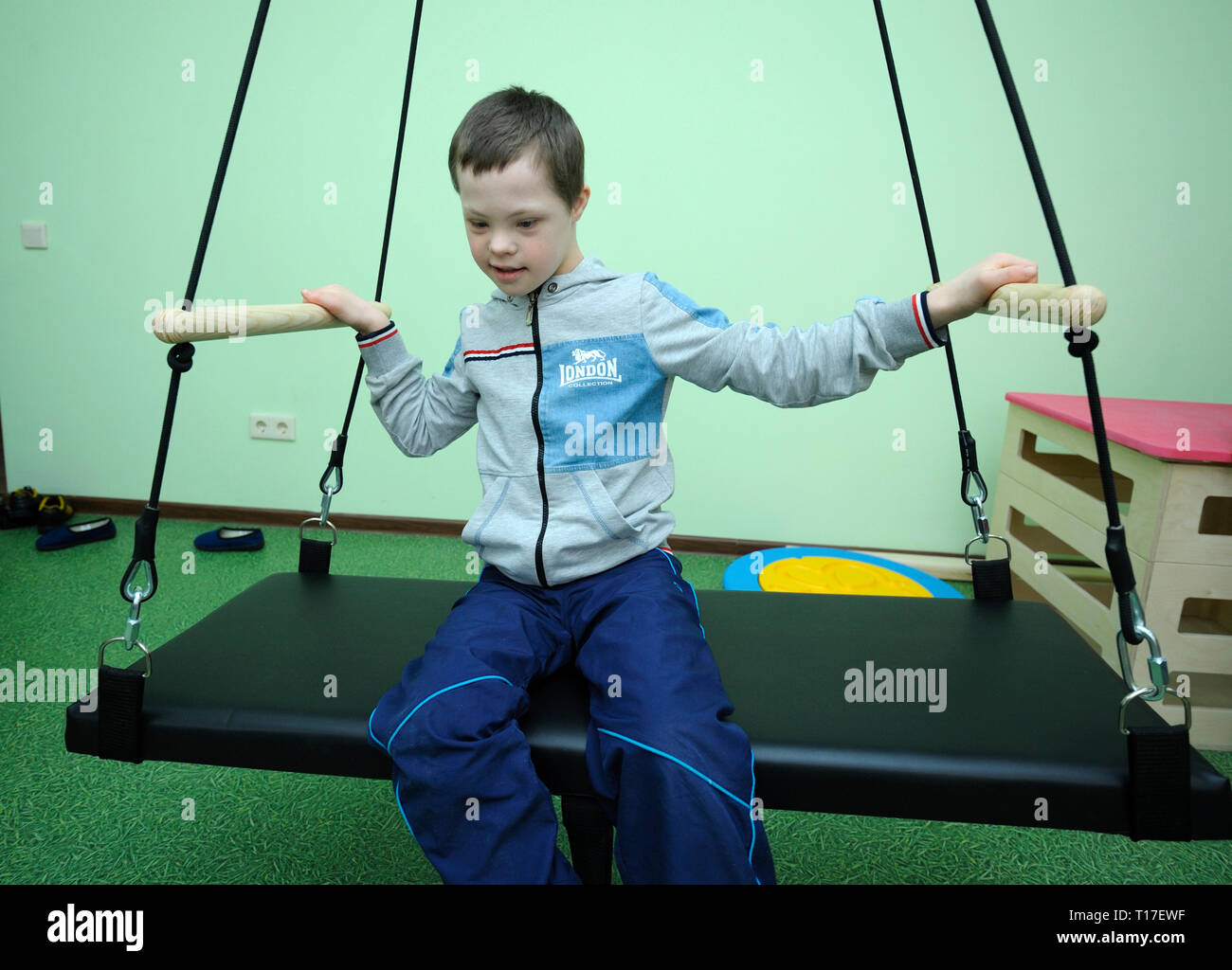 . Improving motor control: Down syndrome boy doing exercises at the ...