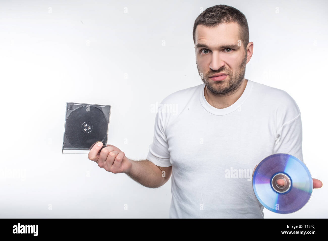 Young man holding a compact disk in one hand and a box from it in ...