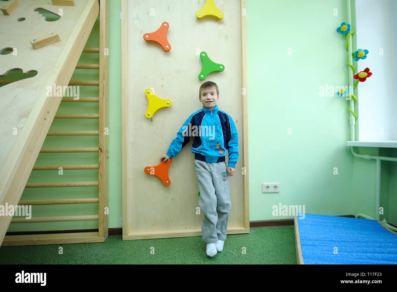 . Improving motor control: Down syndrome boy doing exercises at the ...
