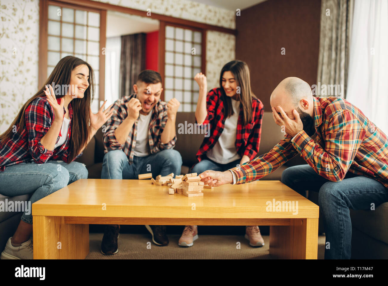 Friends plays jenga at home, the tower has fallen Stock Photo - Alamy