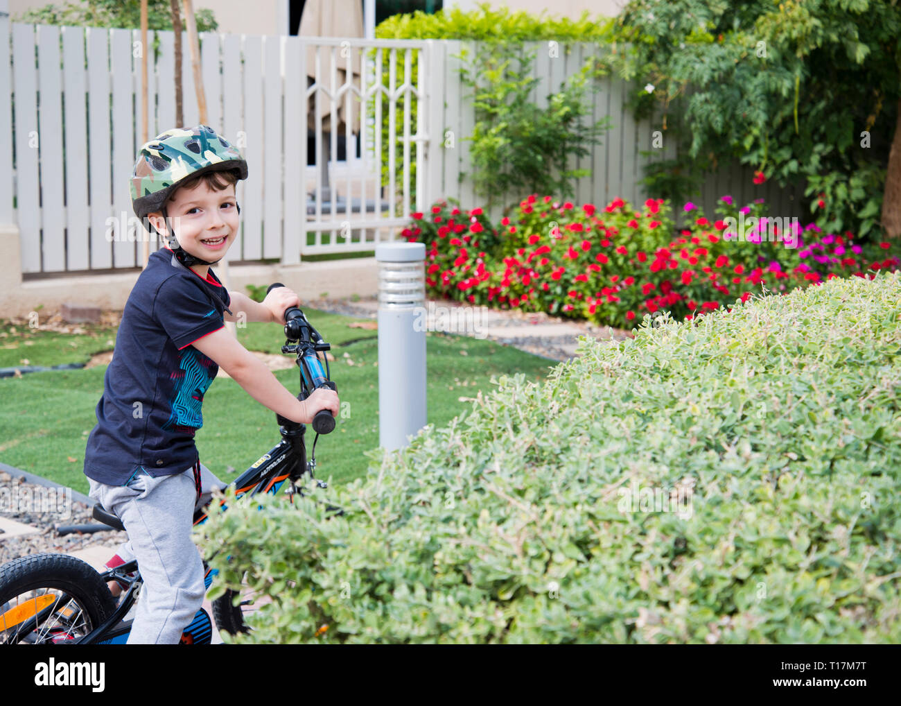 side view young boy sitting on bike resting looking at camera getting ...