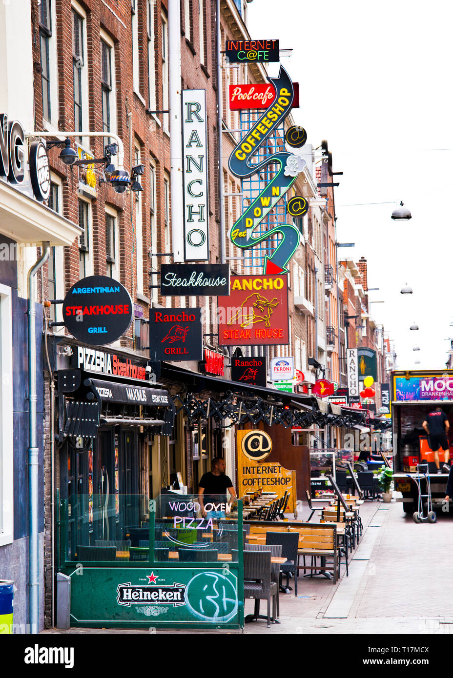 narrow side street lots of colorful designed neon signs advertising ...