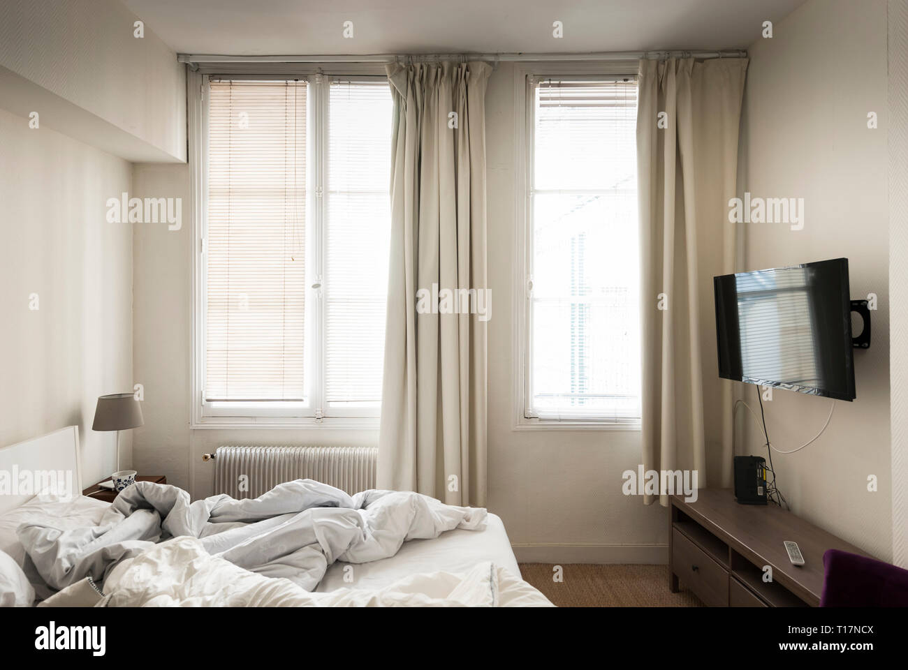 Window with blinds and untidy bed Stock Photo - Alamy