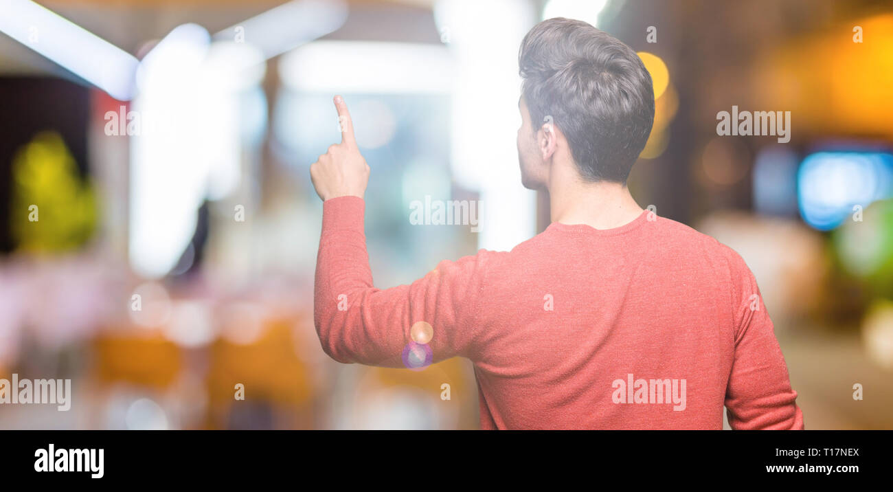 Young handsome man over isolated background Posing backwards pointing ...