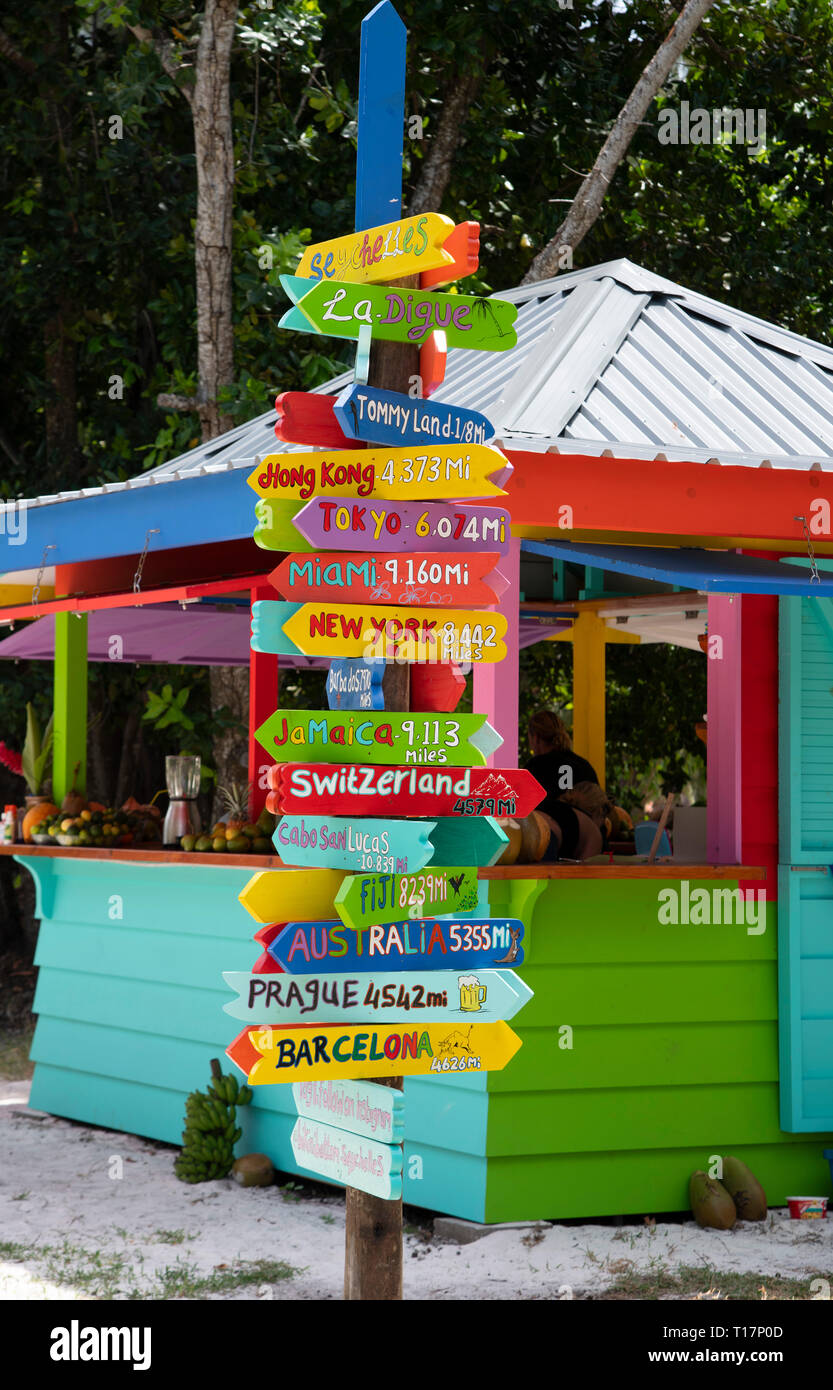 Colourful wooden destination signs in front of a juice bar on La Digue ...