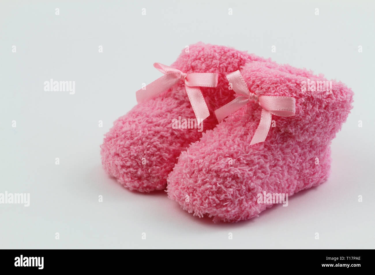 Pink baby booties on white background with copy space Stock Photo - Alamy