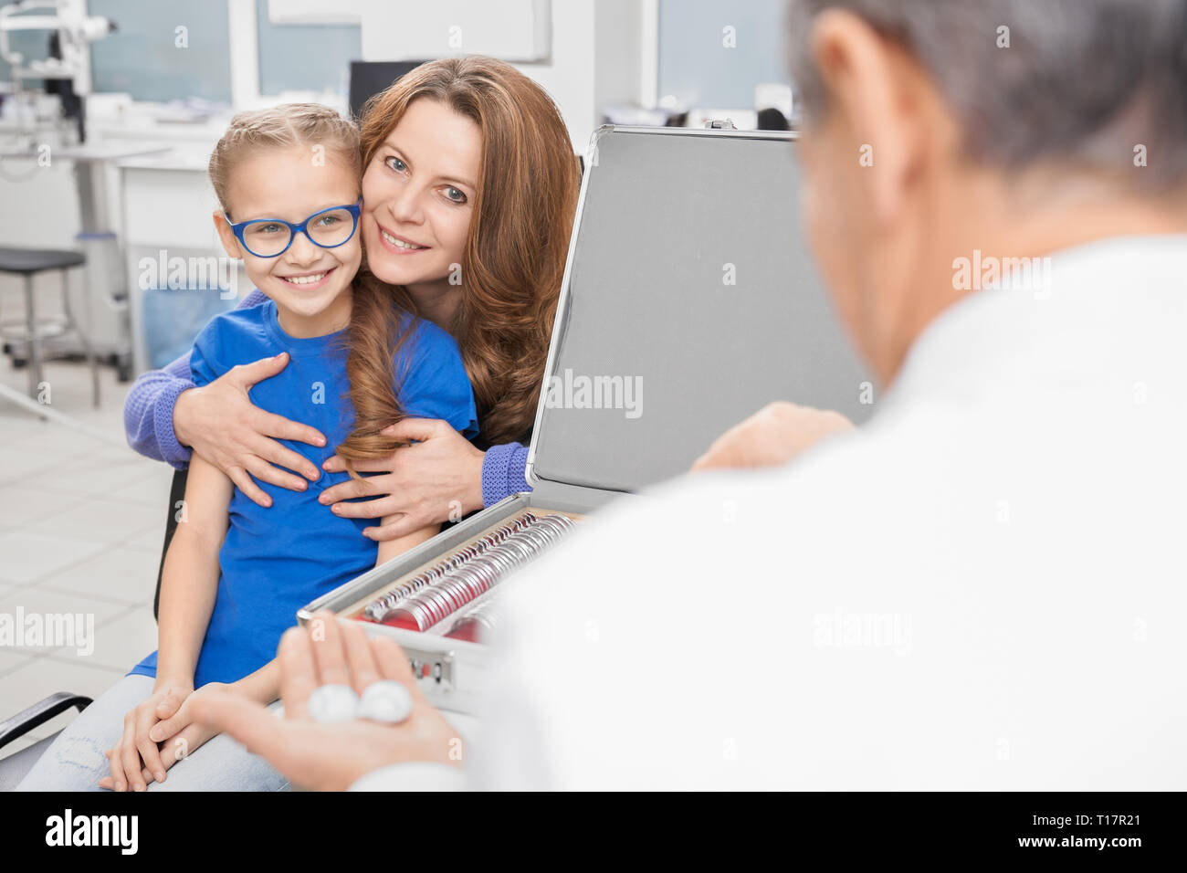 Doctor eye specialist offering contact lenses for patient. Pretty child ...