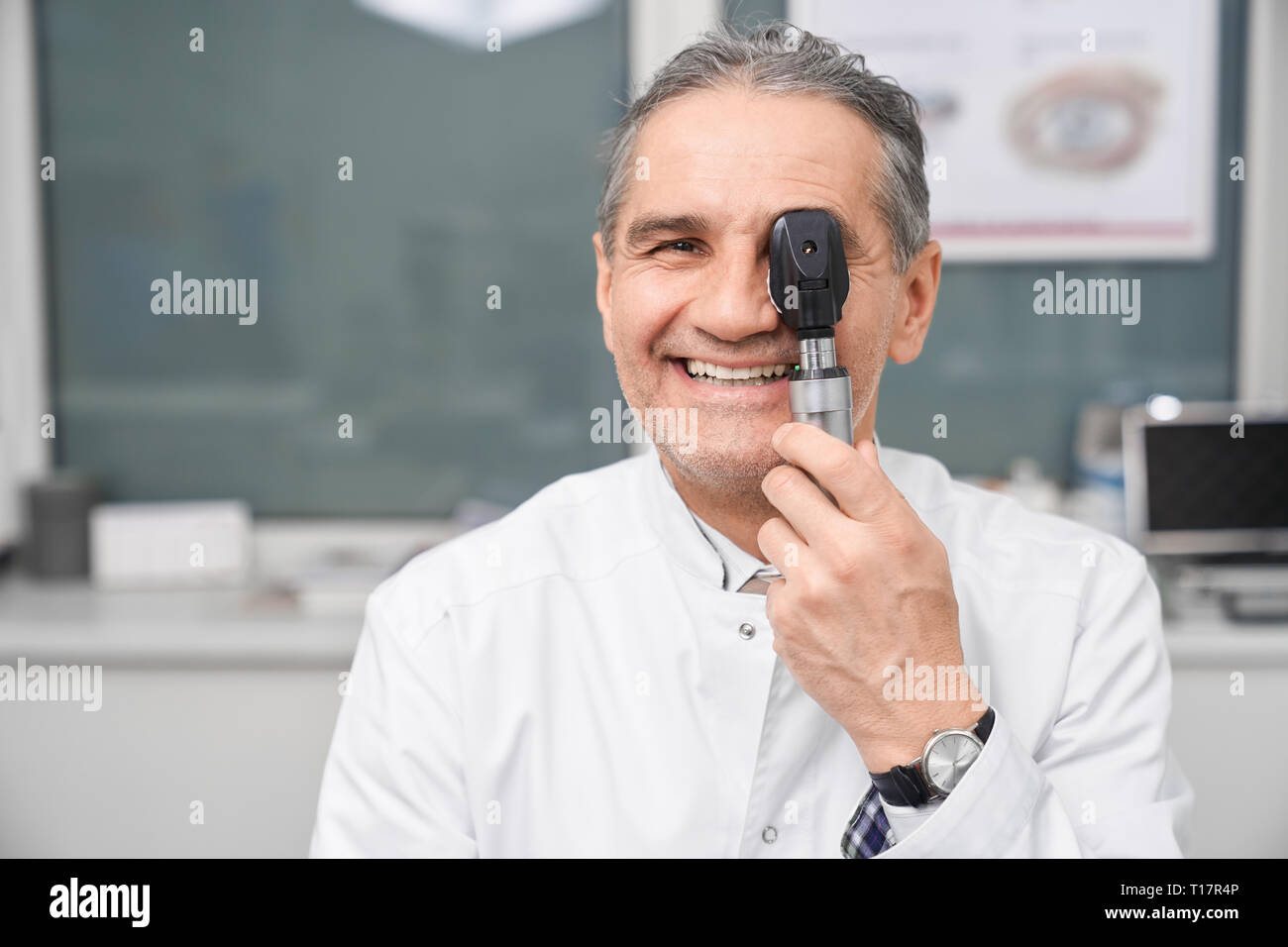 Doctor optometrist posing with special eye equipment in medical clinic ...