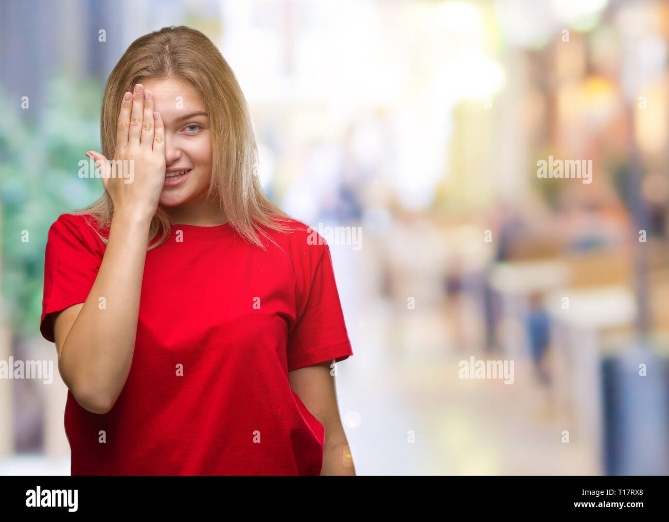 Young caucasian woman over isolated background covering one eye with ...