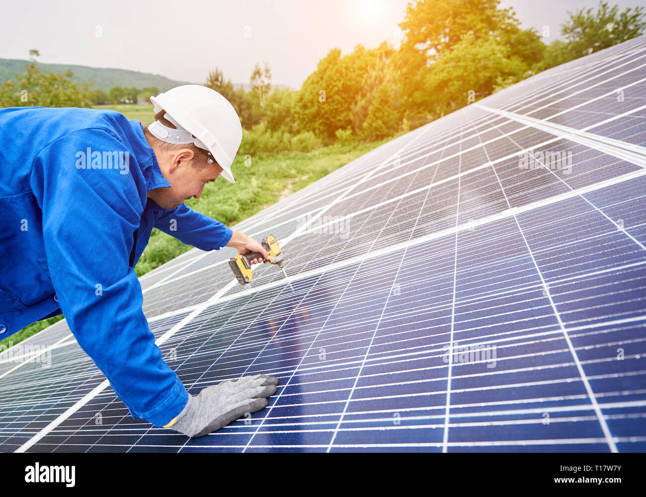 Construction worker connects photo voltaic panel to solar system using ...