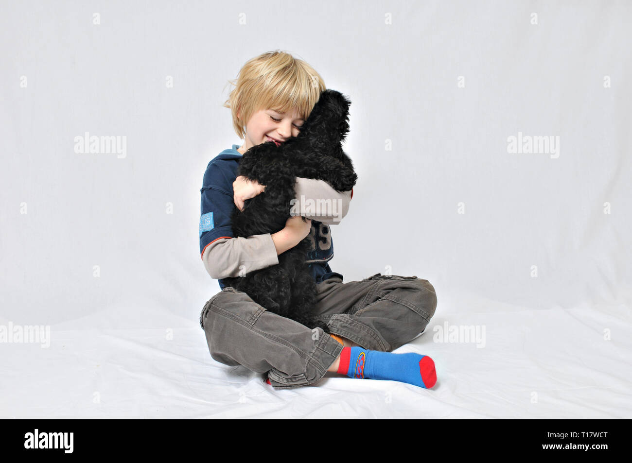 A young boy with missing teeth cuddles his pet dog Stock Photo - Alamy