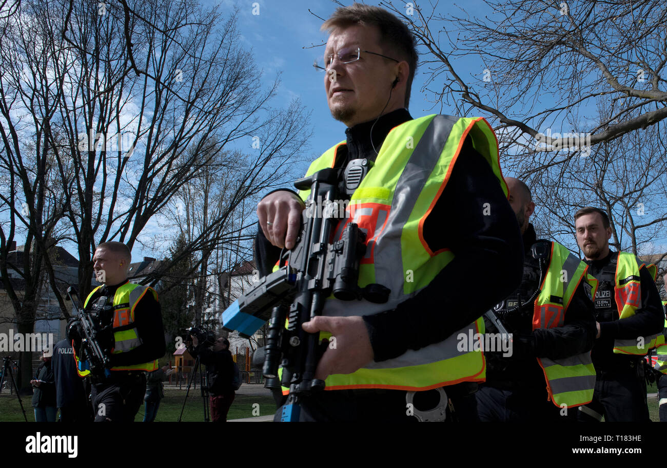 Berlin, Germany. 24th Mar, 2019. Policemen walk with weapons in their ...
