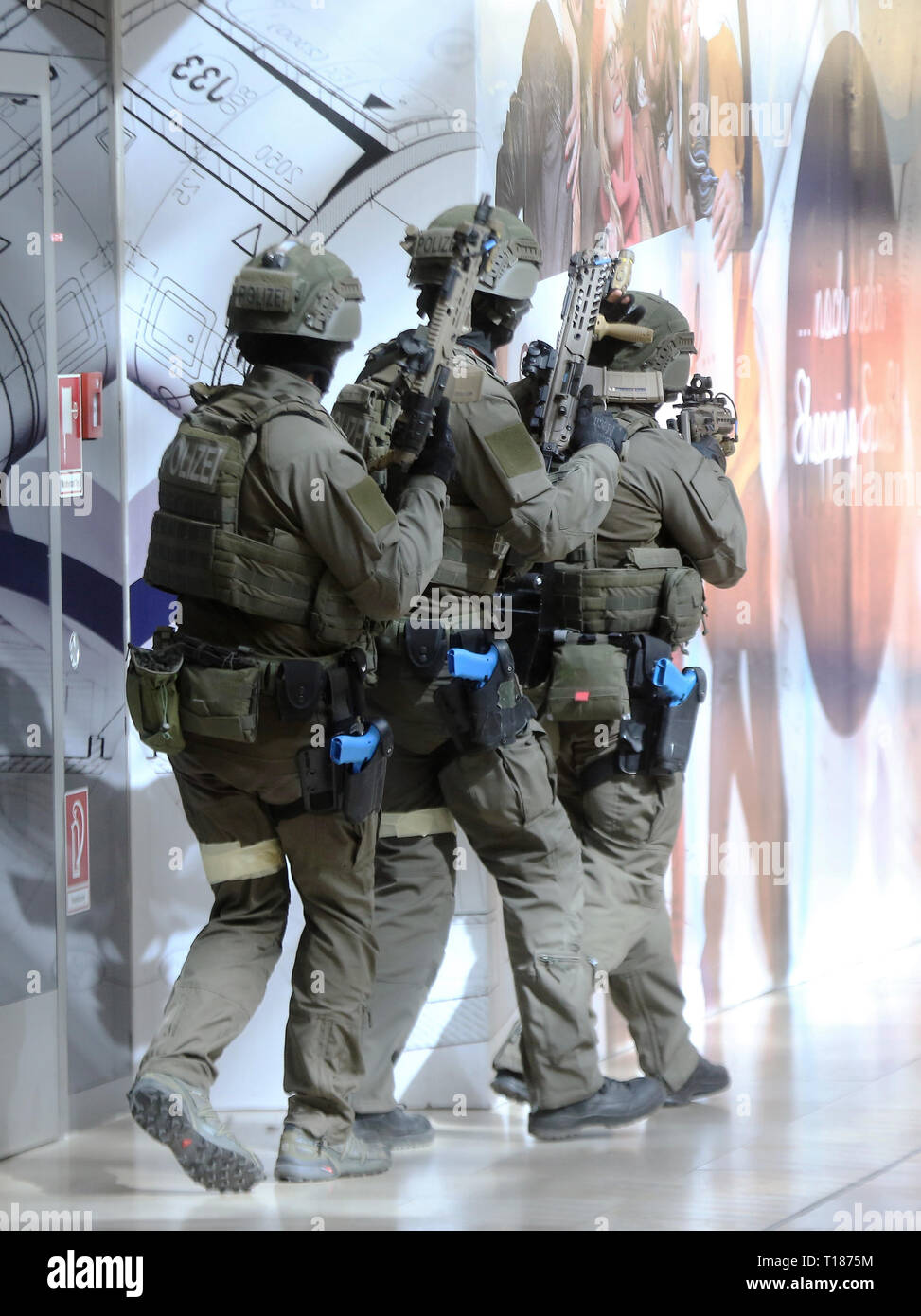 Berlin, Germany. 24th Mar, 2019. Policemen are standing with weapons in ...