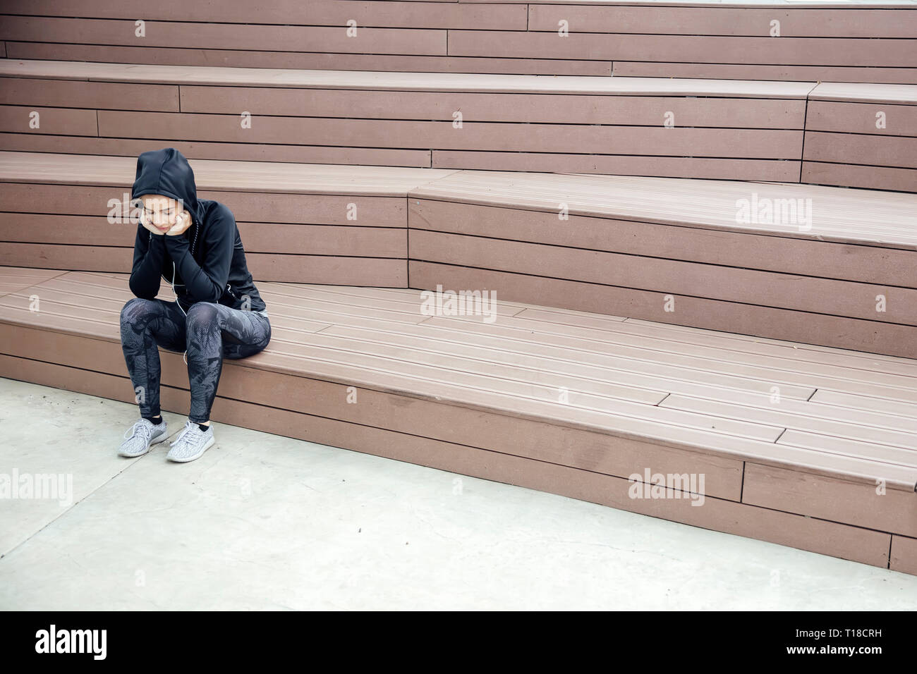 Sad and frustrated sporty young woman sitting alone outdoor Stock Photo ...