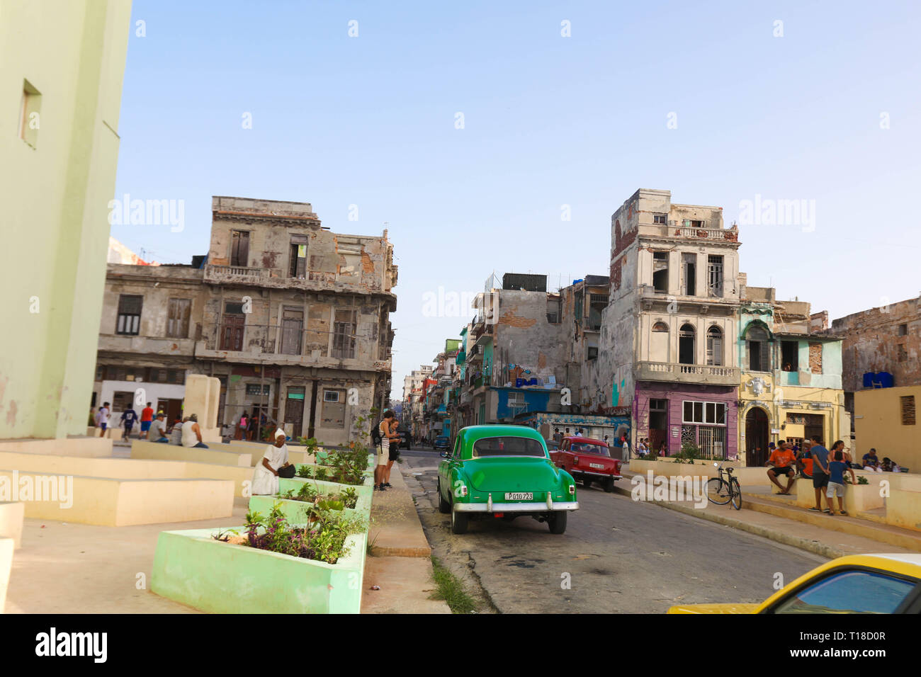 cuban Typical street scene with people, old cars and colorful buildings ...