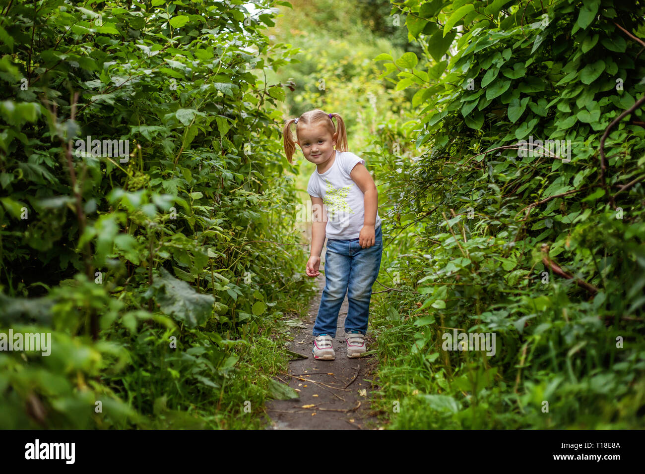 Portrait of happy cute little girl outdoor. Kid palying in park, garden ...