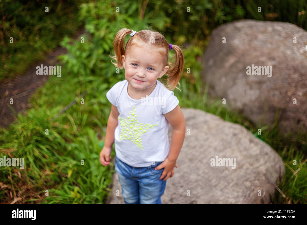 Portrait of happy cute little girl outdoor. Kid palying in park, garden ...
