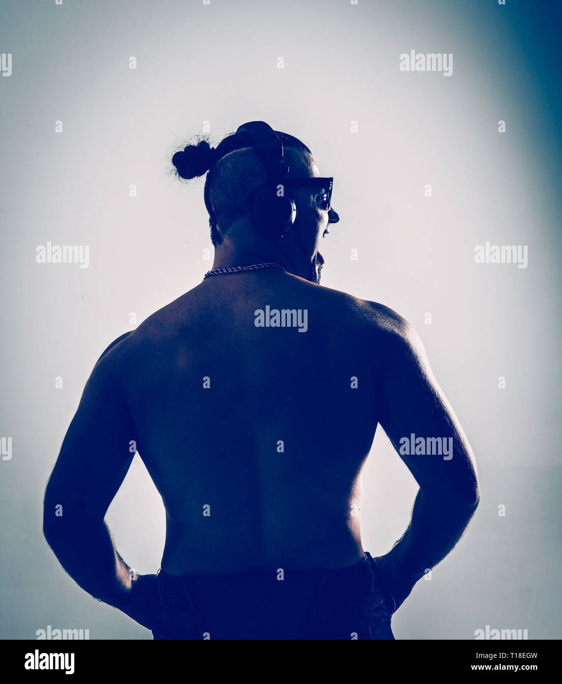 rear view - the rapper shirtless with headphones and stylish hai Stock ...