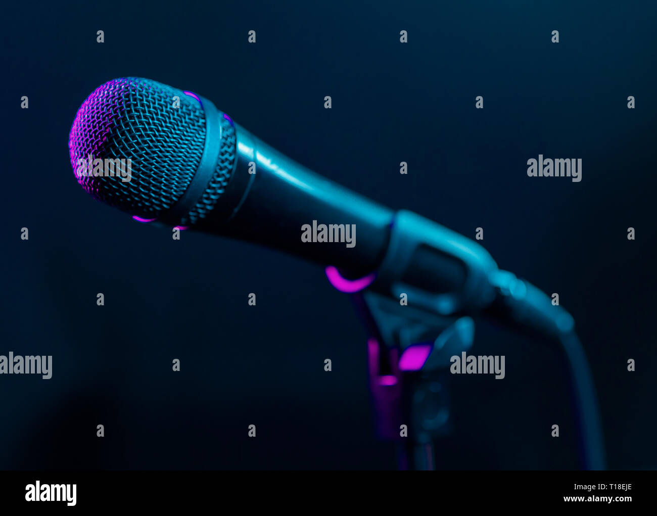 Microphone on black background with colorful pink and turquoise light ...