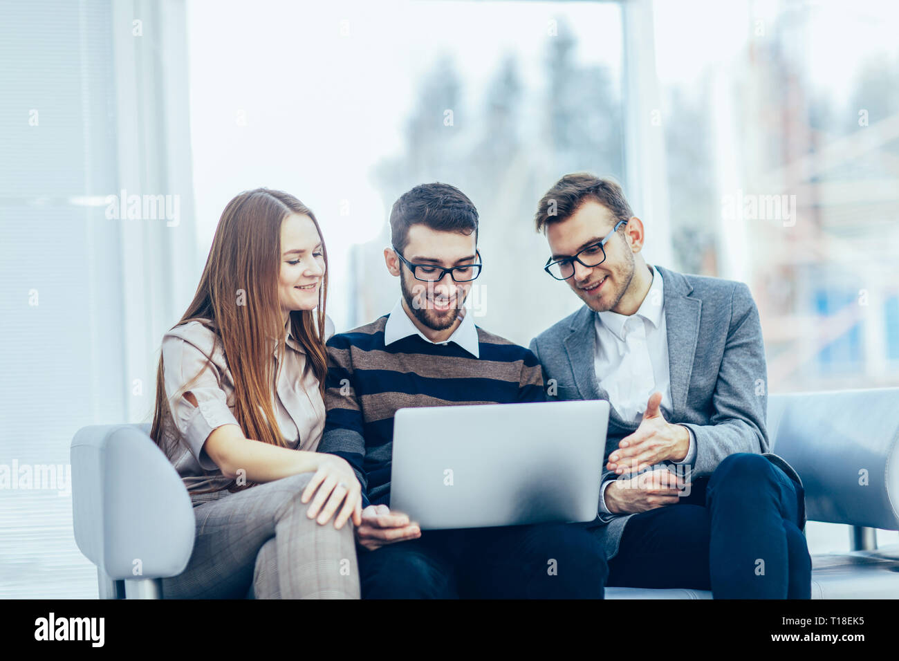 employees with a laptop sitting in the lobby of the office Stock Photo ...