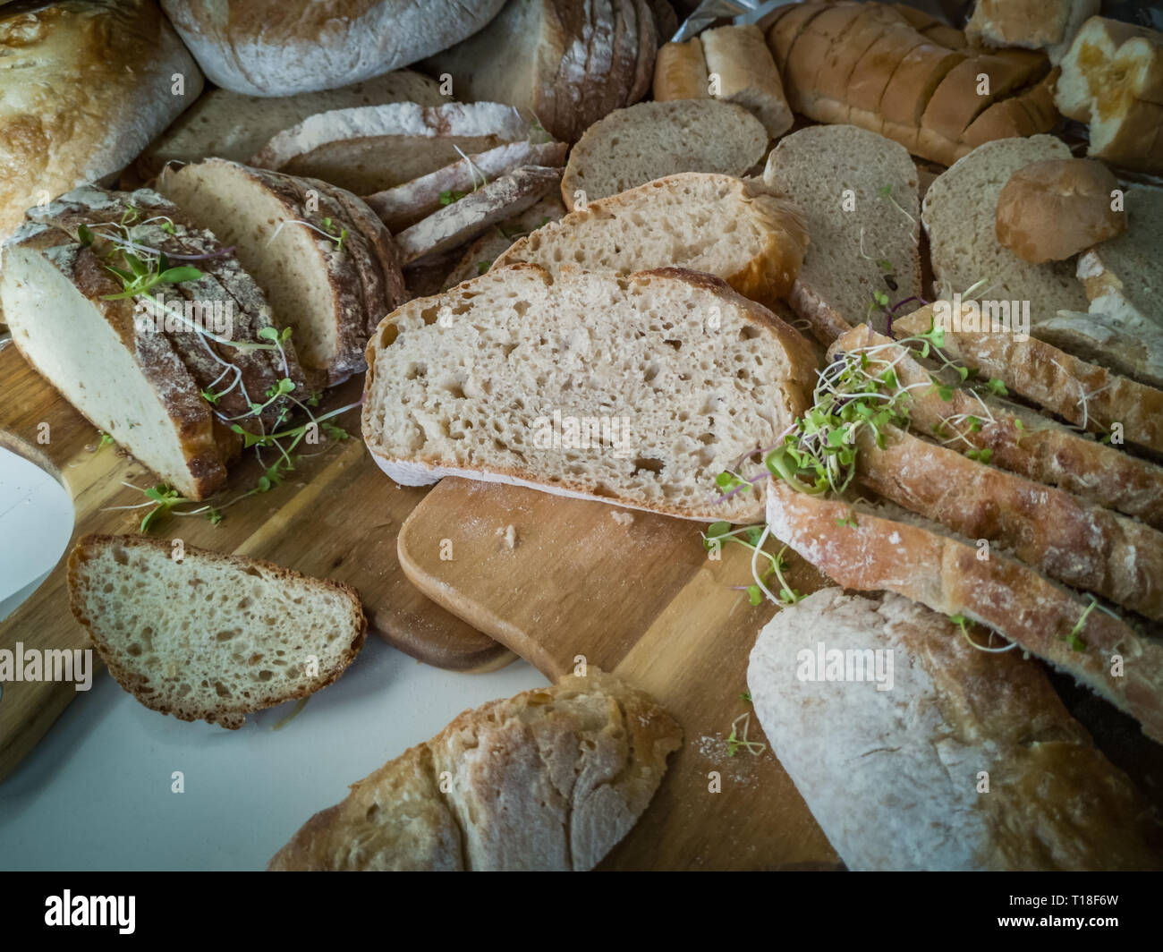 Selection of crusty sliced breads on wooden cutting board Stock Photo ...
