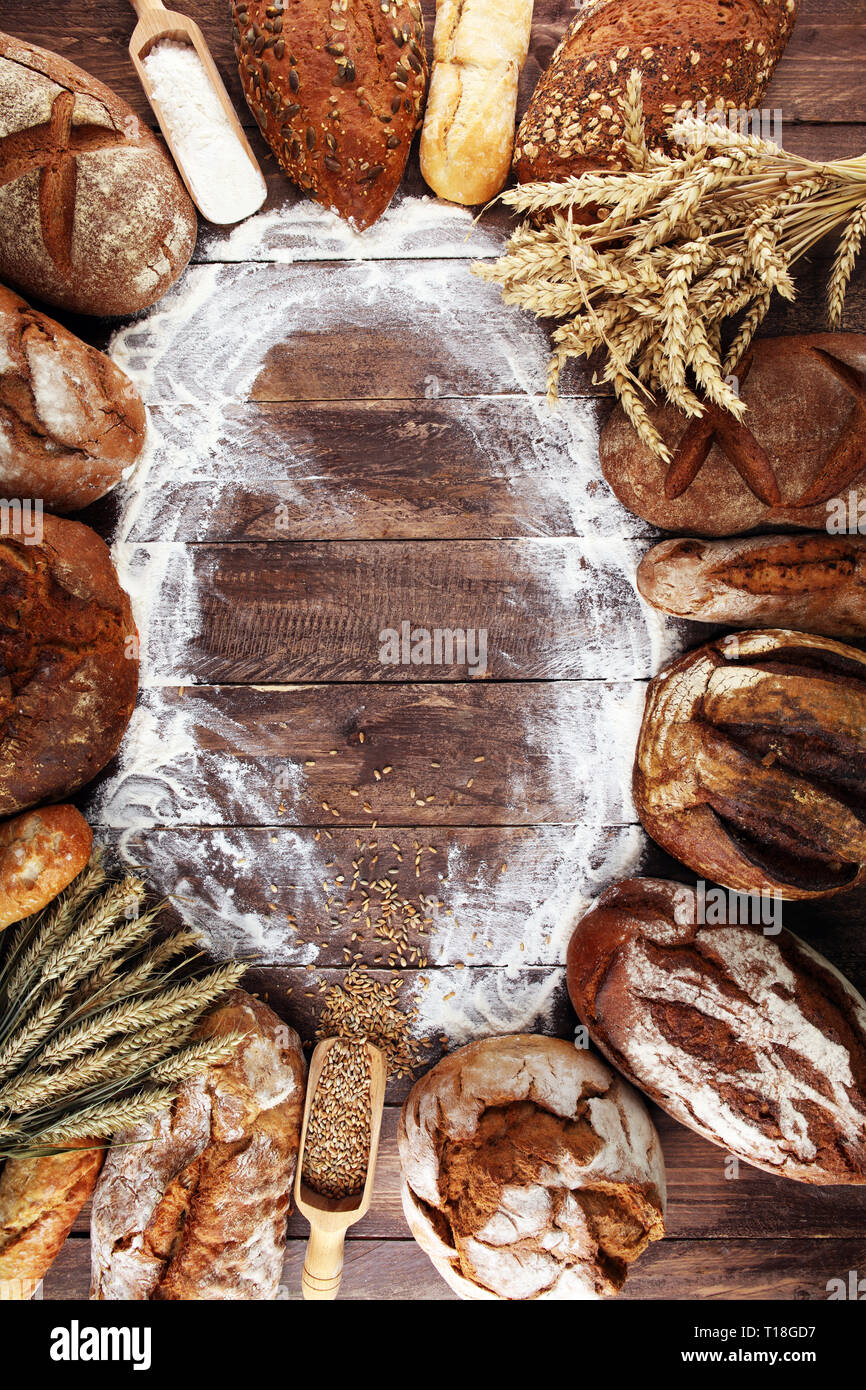Different kinds of bread and bread rolls on board from above. Kitchen ...