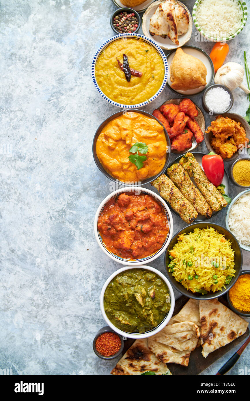 Composition of Indian cuisine in ceramic bowls on stone table. Tikka ...