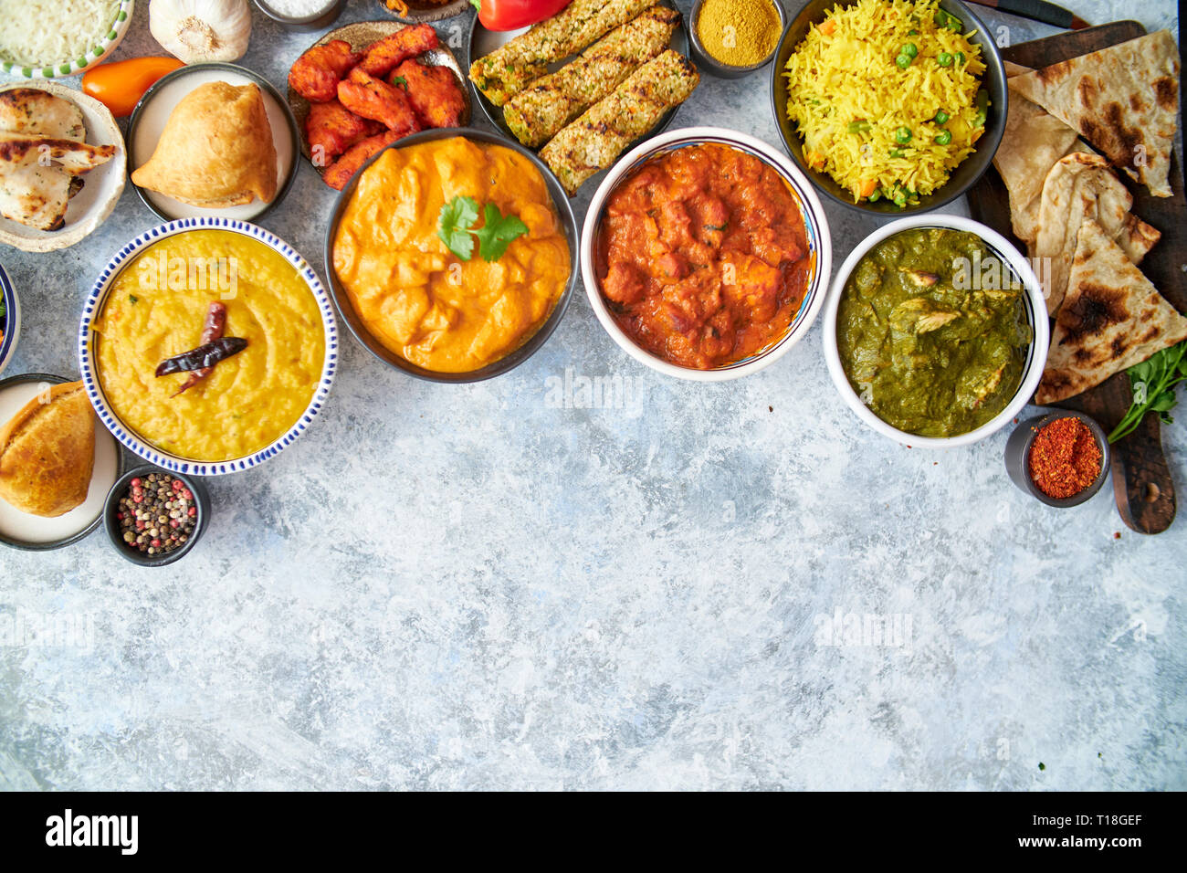 Composition of Indian cuisine in ceramic bowls on stone table. Tikka ...