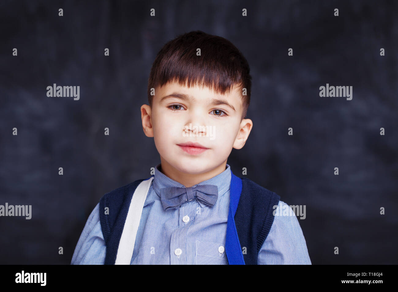 Portrait of cute little child boy wearing school uniform on black ...