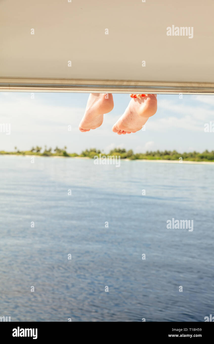 First class seats. Close-up of kids feet at upper boat decking ...