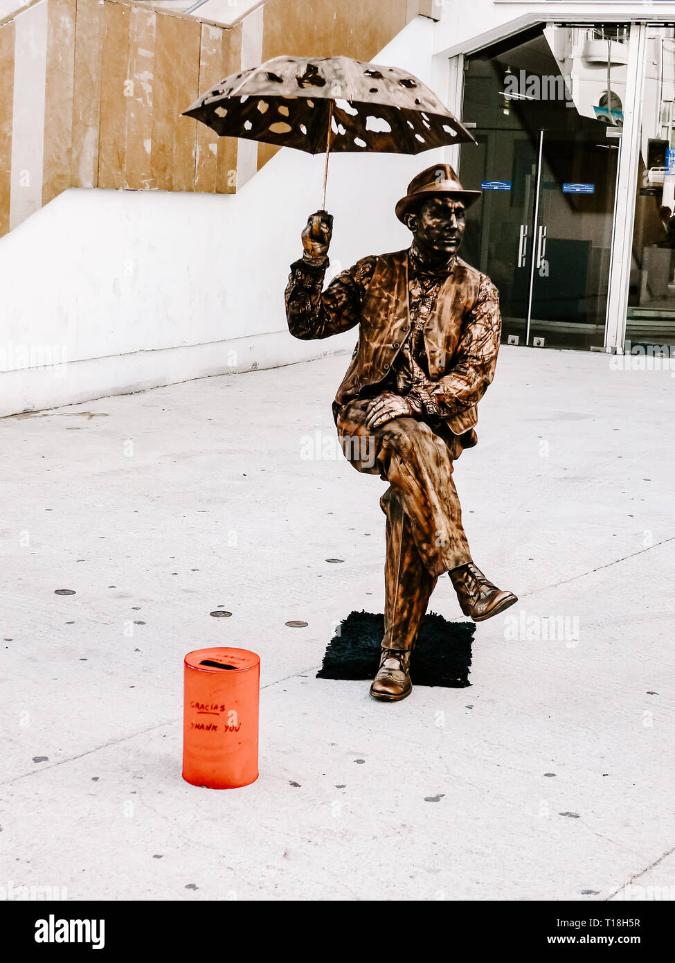 Copper coated street performer holding umbrella, street statue, copper ...