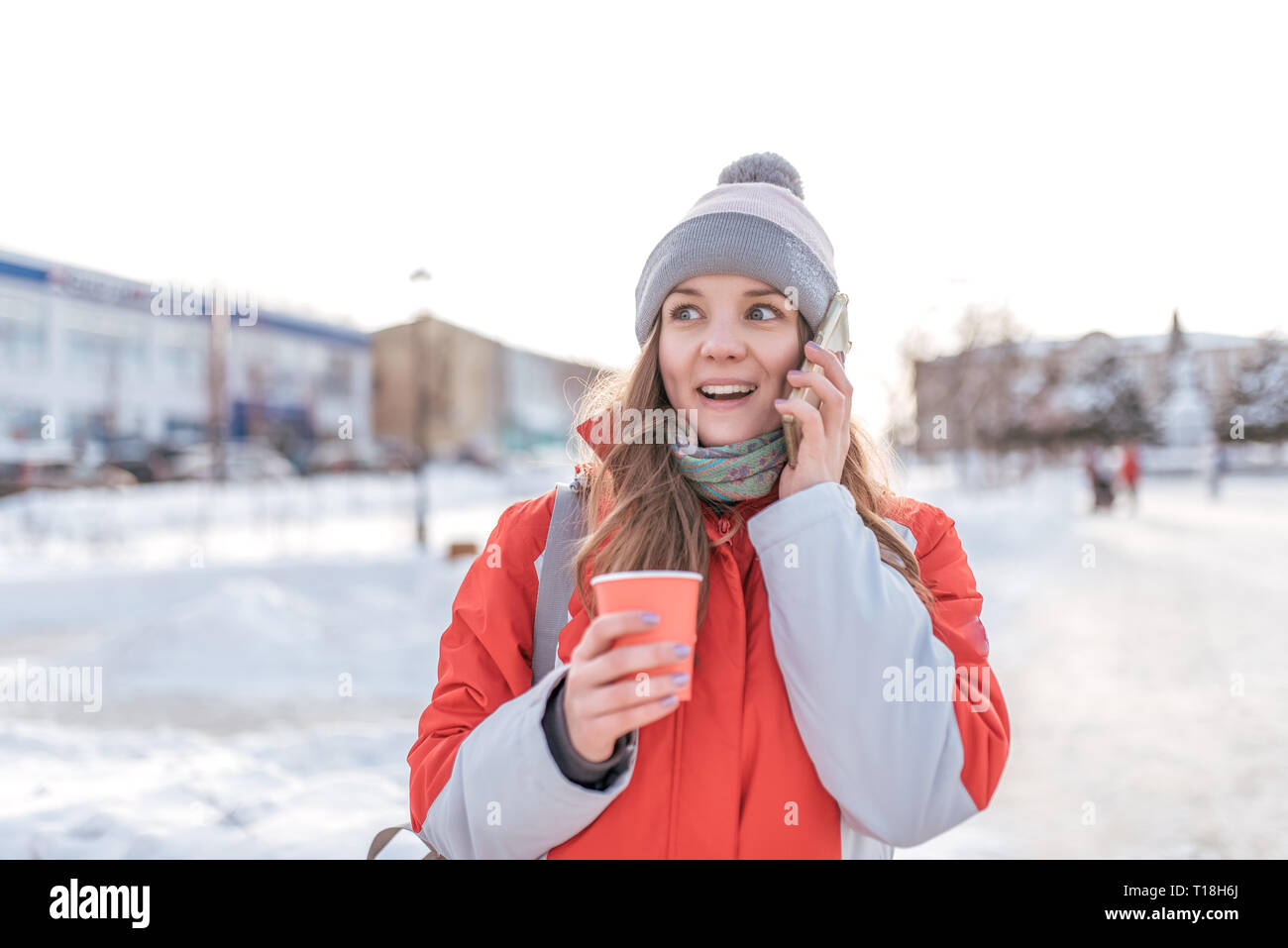 Girl surprised winter in city in fresh air on background of snow and ...