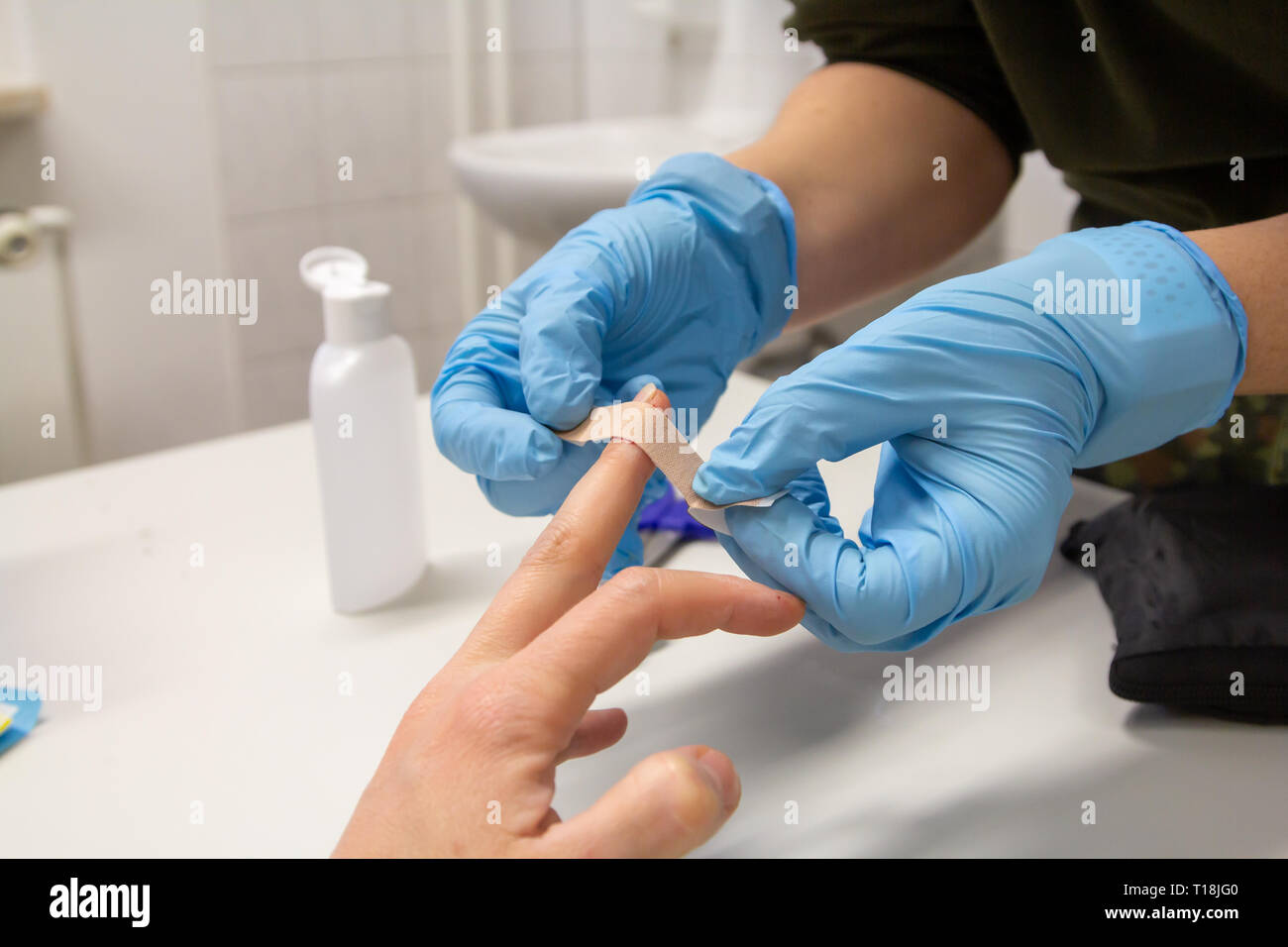 a doctor sticks a plaster on a finger Stock Photo - Alamy