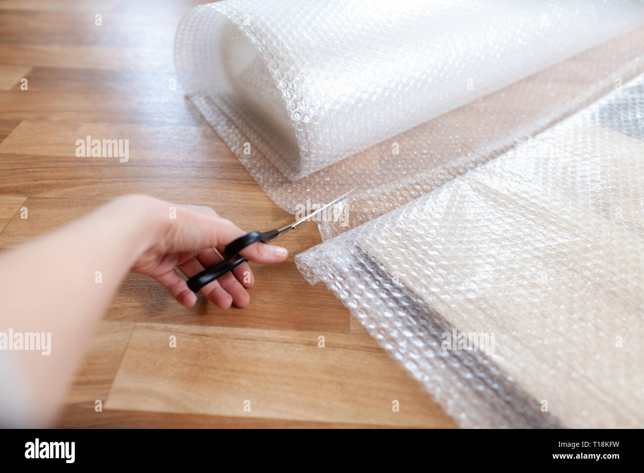A woman cuts packaging material with a scissor Stock Photo - Alamy