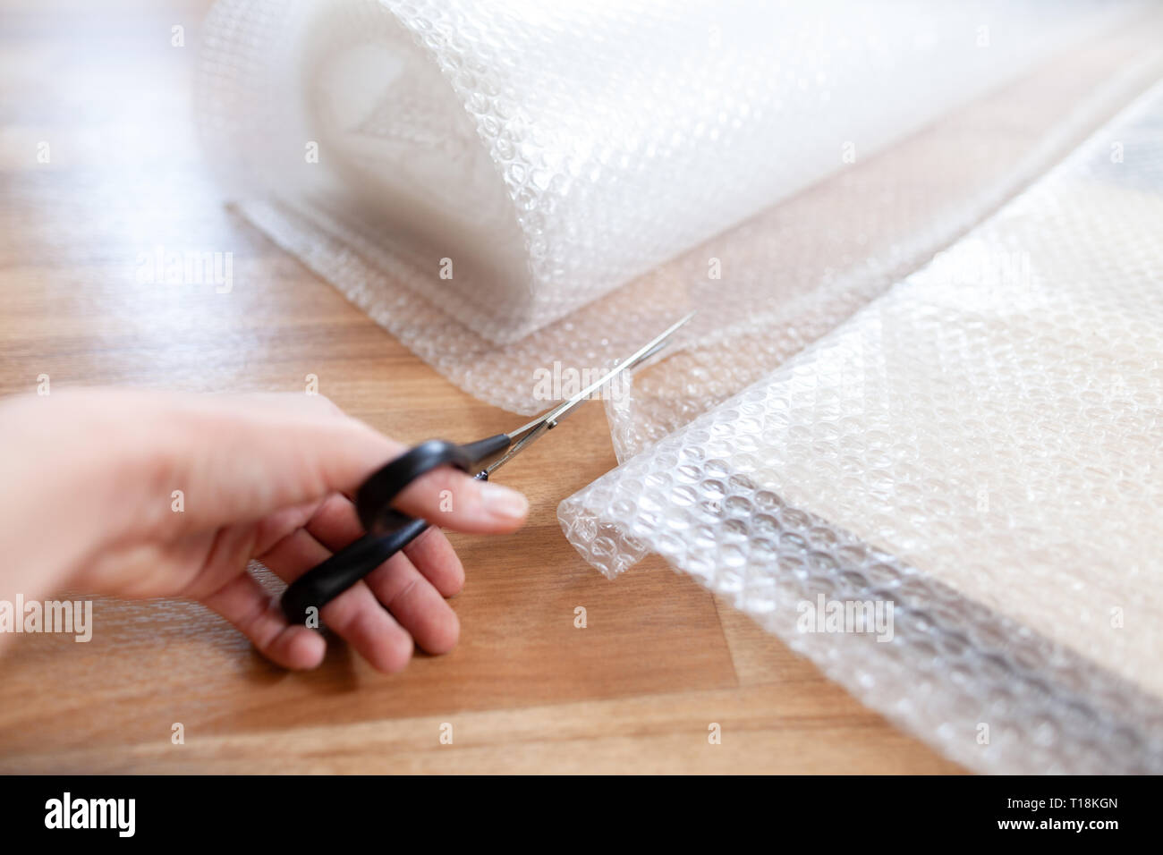 A woman cuts packaging material with a scissor Stock Photo - Alamy