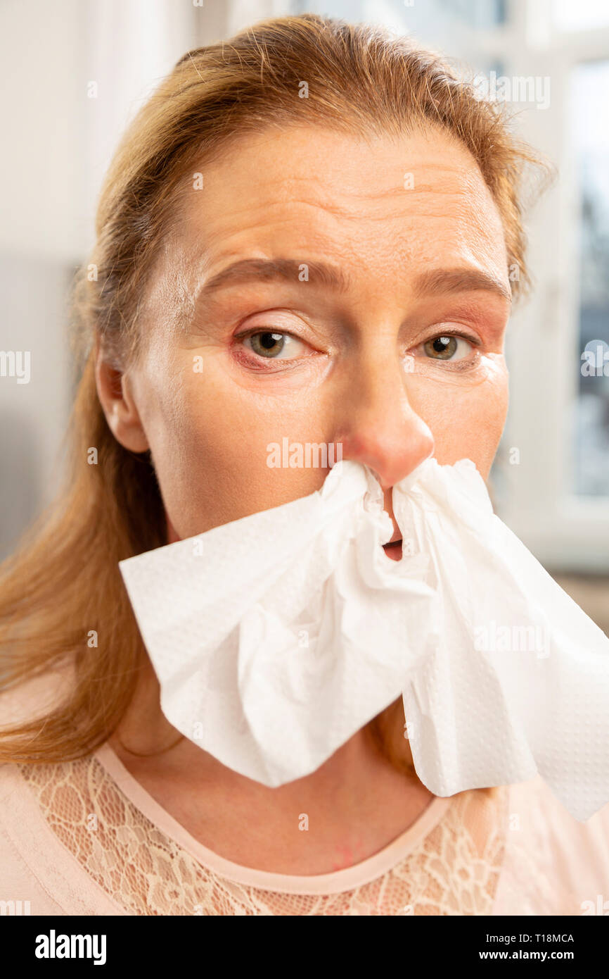 Green-eyed woman with allergy having napkin in her nose Stock Photo - Alamy
